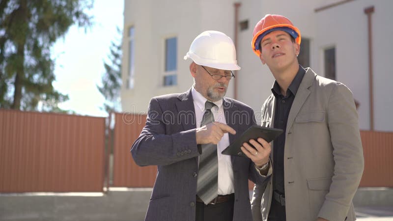 Two Business Partners Looking on Building Plans on Tablet. 4K Stock ...