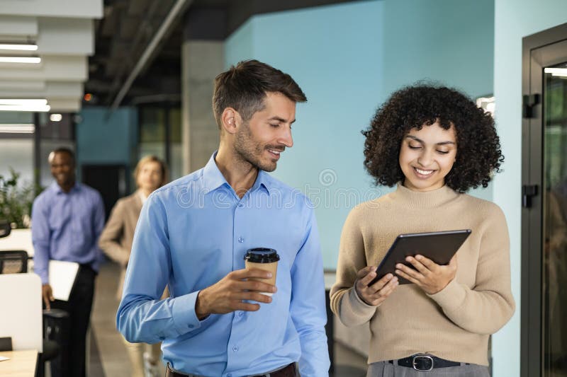 Two Business People Discussing Work Together Using a Tablet in a Modern ...