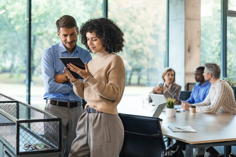 Two Business People Discussing Work Together Using a Tablet in a Modern ...