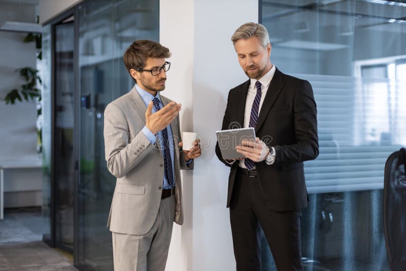 Two Business People Discussing Work Together Using a Tablet in a Modern ...