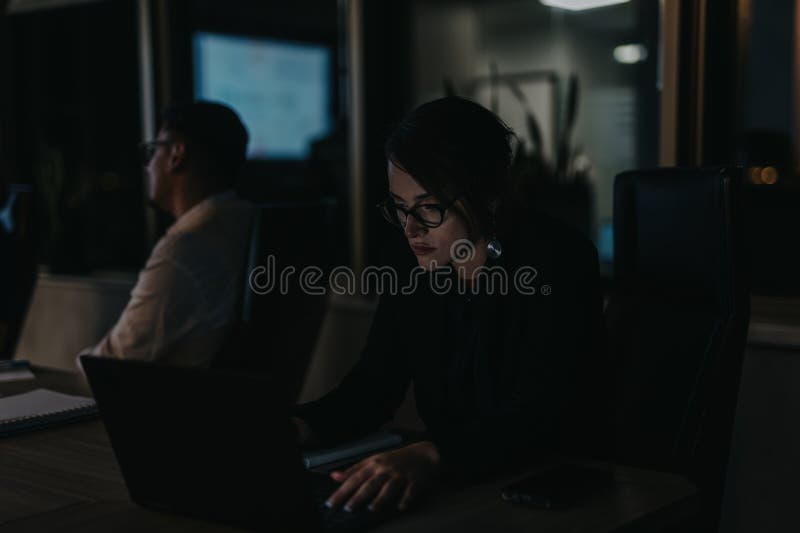 Business People Working Late at Night in a Dimly Lit Office Stock Image ...