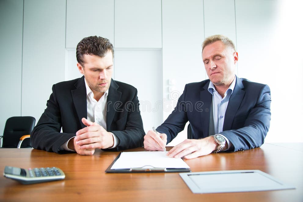 Two Business People Signing a Document Stock Photo - Image of paperwork ...