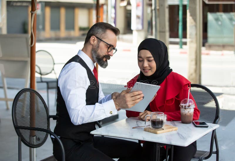 Two Business People Sitting at Cafe Working on New Project. Stock Photo ...