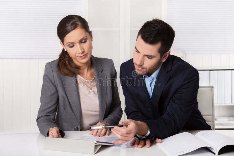 Two Business People Working in a Team Talking Together in the of Stock ...