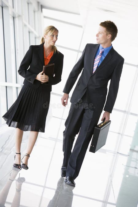 Two Business People Walking in Corridor Talking Stock Image - Image of ...