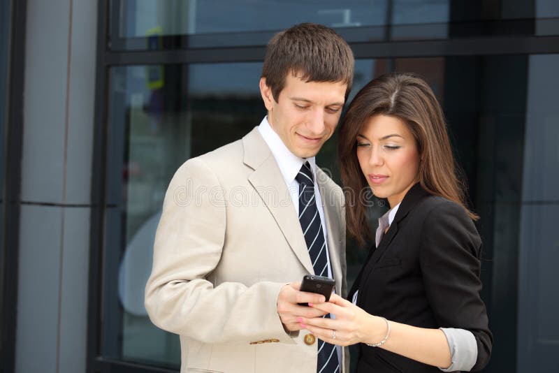 Two Business Persons Watching a Mobile Phone Stock Photo - Image of ...
