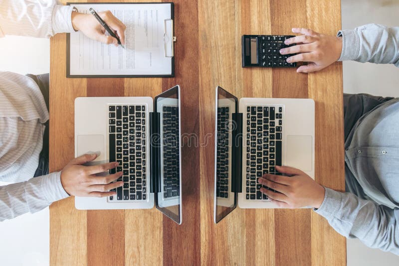 Two Business Persons Working at Office Desk and Discussing Using Stock ... Two Business Persons Working at Office Desk and Discussing Using Stock ...