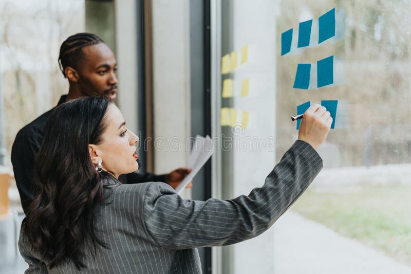Two Business Professionals Collaborating on a Project Using Sticky ...