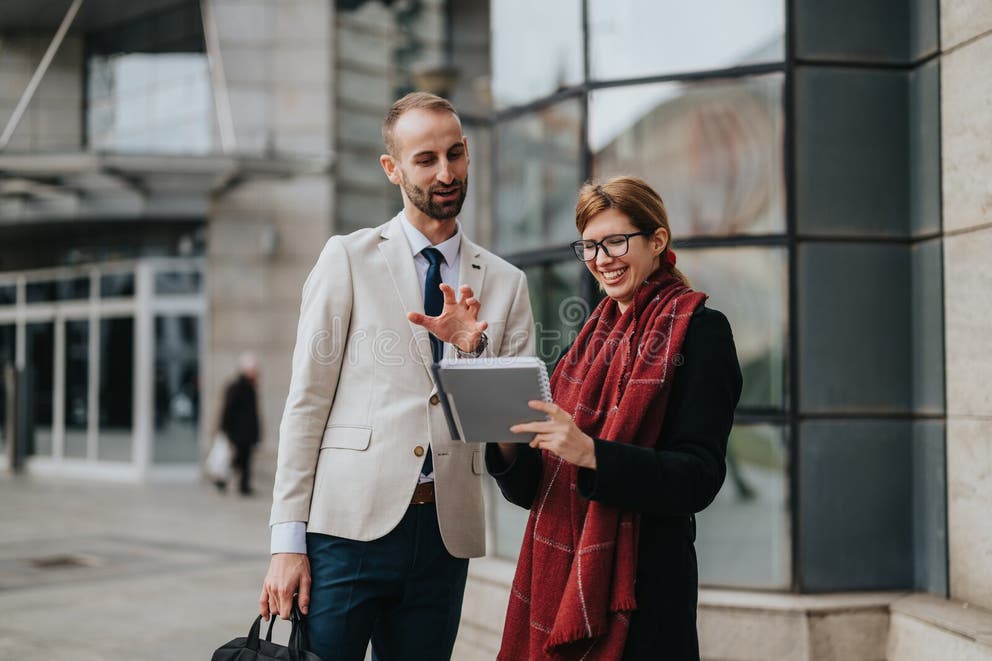 Two Business Professionals Sharing Information on a Tablet Outdoors ...