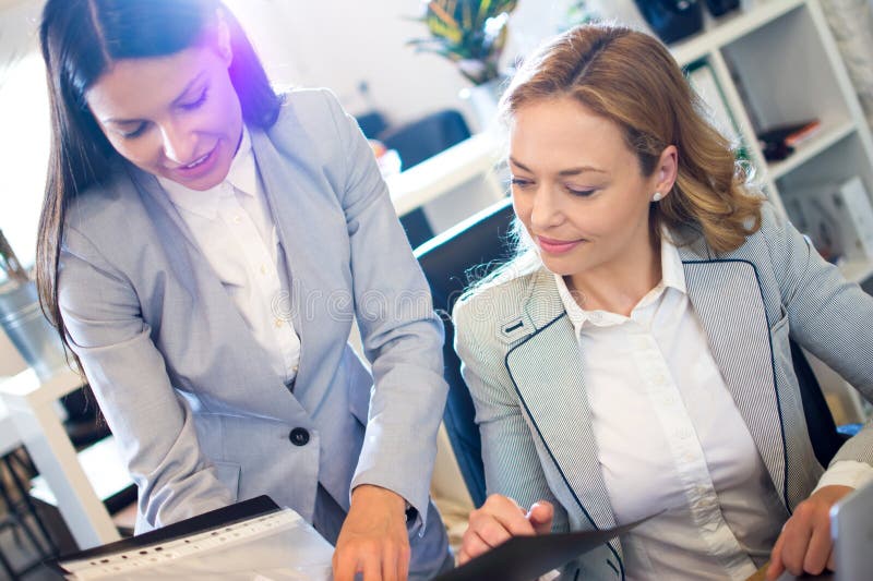 Two Business Women Discussing Documents in Office. Stock Photo - Image ...