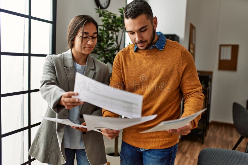Two Business Workers with Serious Expression Reading Paperwork Standing ...