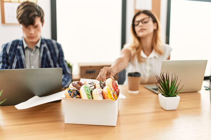 Two Business Workers Smiling Happy Eating Doughnuts at the Office Stock ...