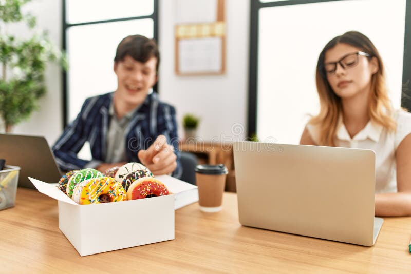 Two Business Workers Smiling Happy Eating Doughnuts at the Office Stock ...