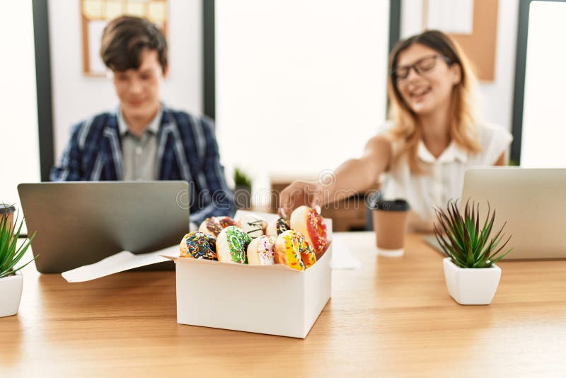 Two Business Workers Smiling Happy Eating Doughnuts at the Office Stock ...