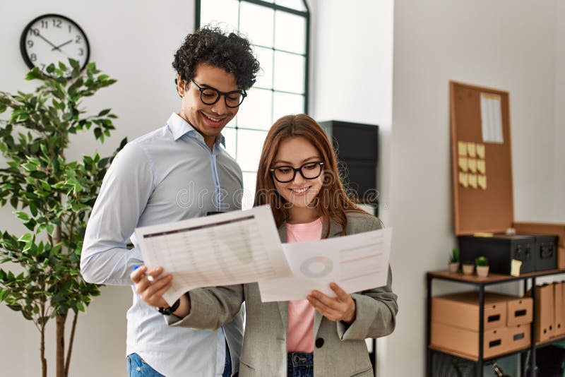 Two Business Workers Smiling Happy Reading Paperwork Working at the ...
