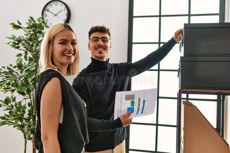 Two Business Workers Smiling Happy Saving Document on File Cabinet at ...