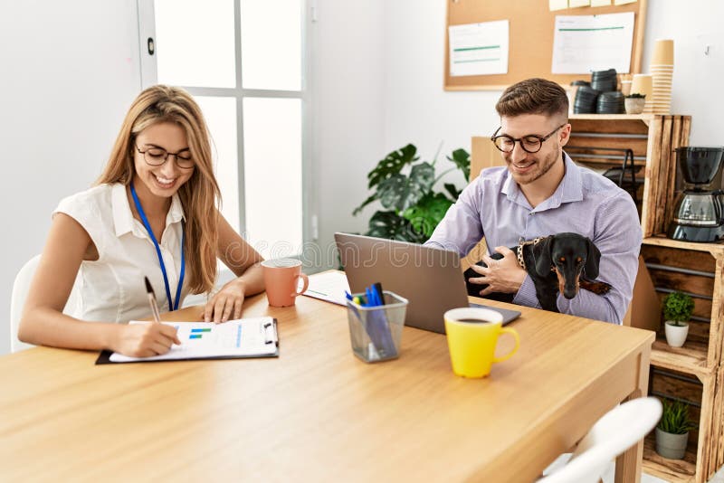 Two Business Workers Smiling Happy Working with Dog at the Office Stock ...