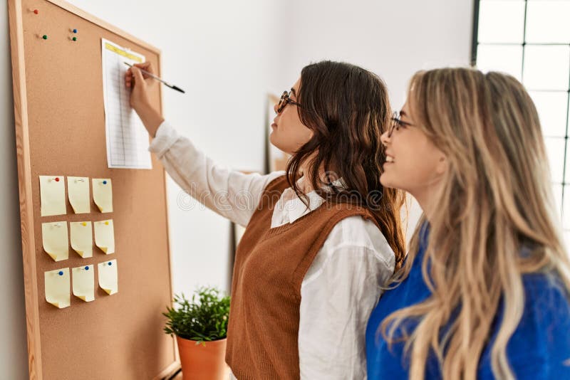 Two Business Workers Smiling Happy Writing at Corkboard Reminder at the ...