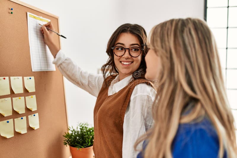 Two Business Workers Smiling Happy Writing at Corkboard Reminder at the ...