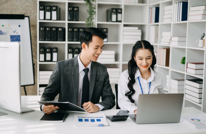 Two Business Workers Talking on the Smartphone and Using Laptop at the ...