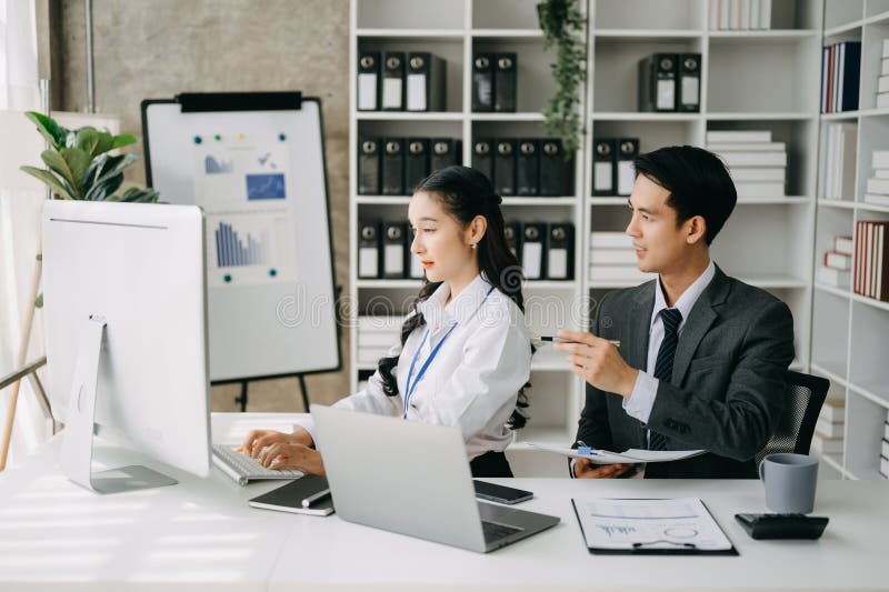 Two Business Workers Talking on the Smartphone and Using Laptop at the ...