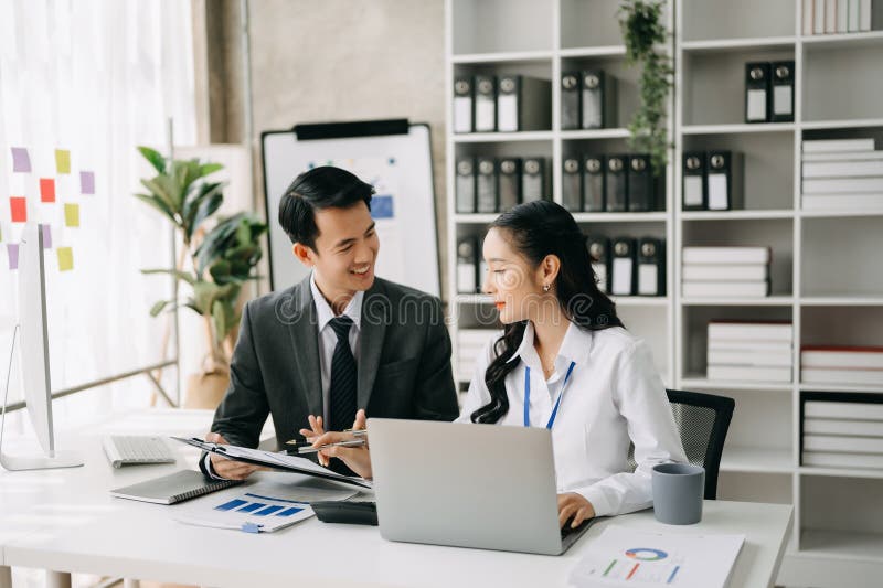 Two Business Workers Talking on the Smartphone and Using Laptop at the ...