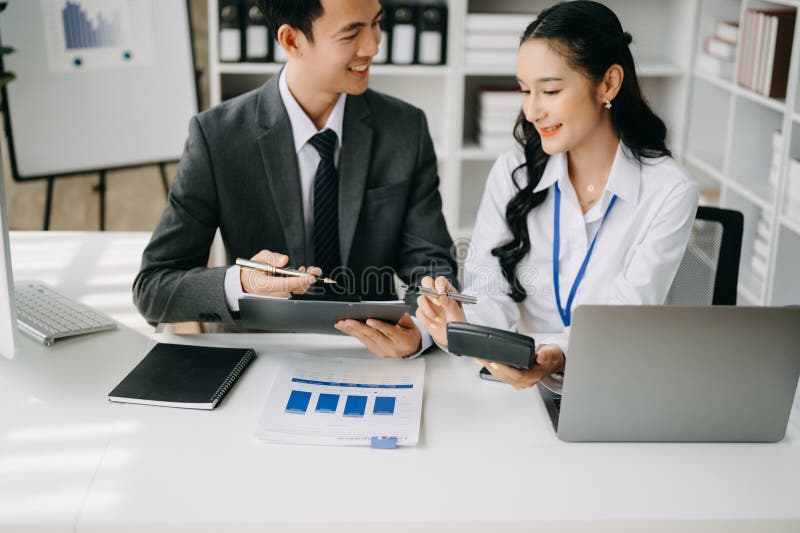 Two Business Workers Talking on the Smartphone and Using Laptop at the ...