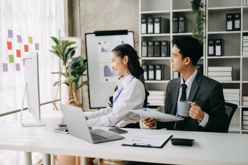 Two Business Workers Talking on the Smartphone and Using Laptop at the ...