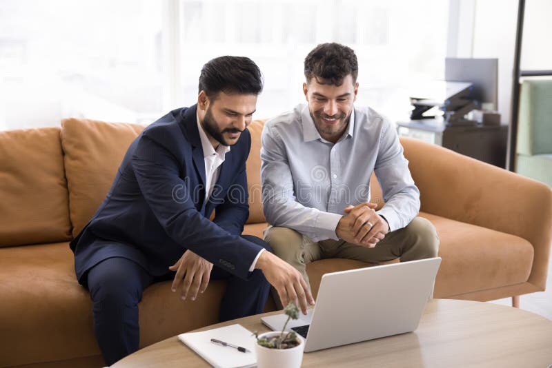 Two Businessmen Engaged in Collaborative Discussion Using Laptop Stock ...