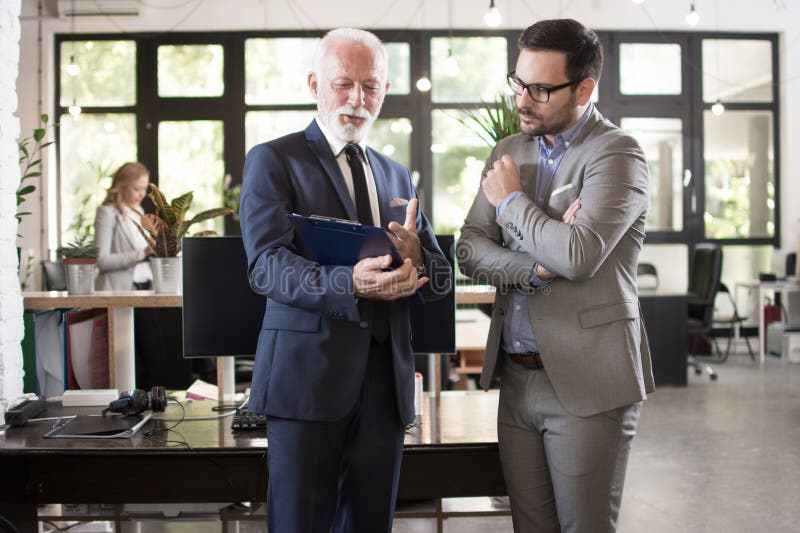 Two Businessmen in Formal Suits Discussing Documents on a Meeting in ...