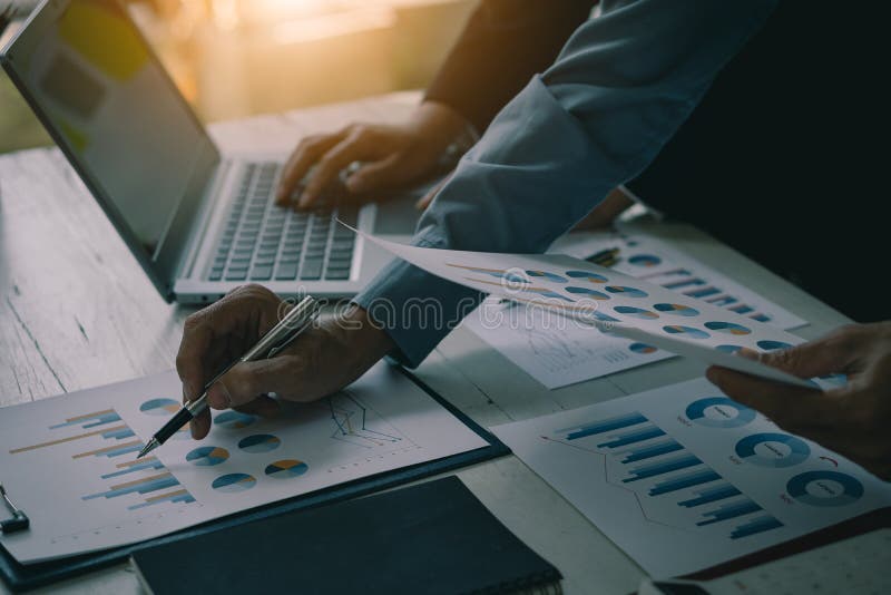 Two Businessmen with Pens Pointing at Financial Market Analysis Charts ...