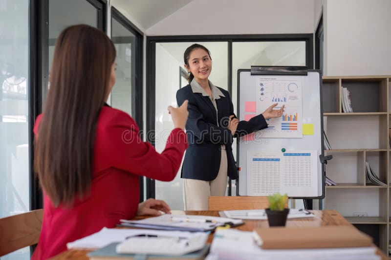 Two Businesswomen Discussing Project Strategy In Office Conference Room