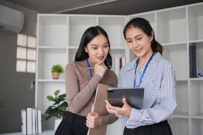 Two Businesswomen Discussing Project with Tablet in Modern Office ...