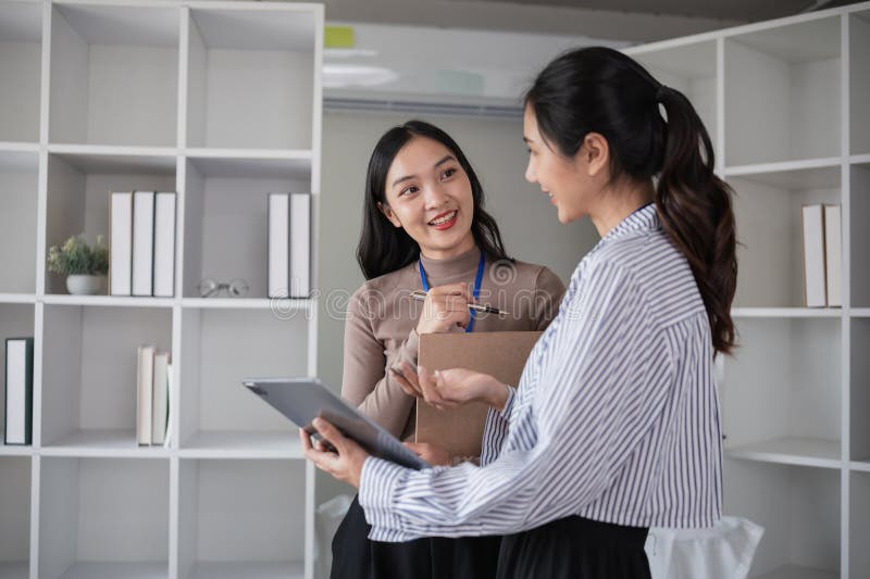 Two Businesswomen Discussing Project with Tablet in Modern Office ...