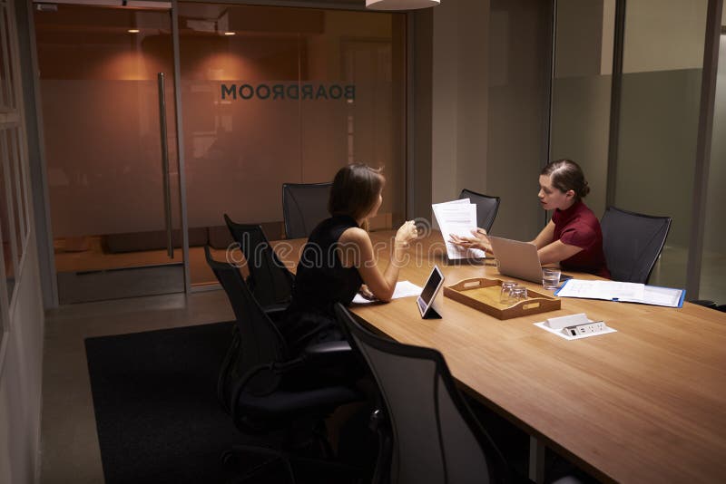 Two Businesswomen Working Late in Office Look at Documents Stock Image ...