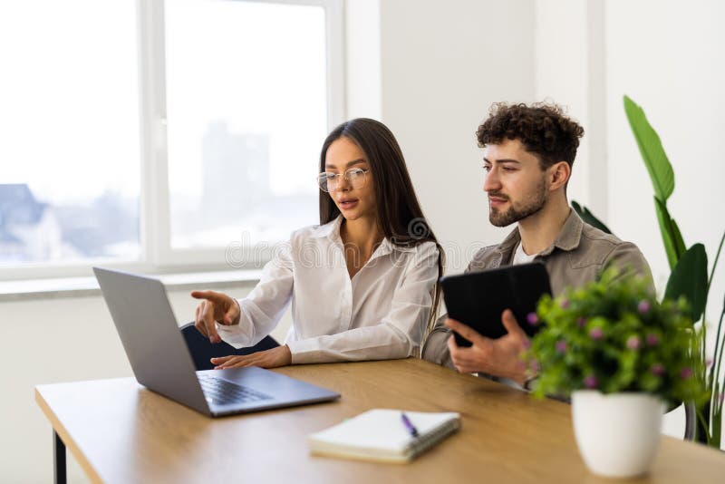 Two Businessworkers Smiling Happy Working Sitting on Desk at the Office ...
