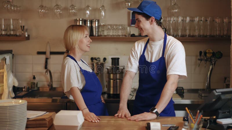 Two Cafe Workers Having a Nice Conversation and Laughing, while ...
