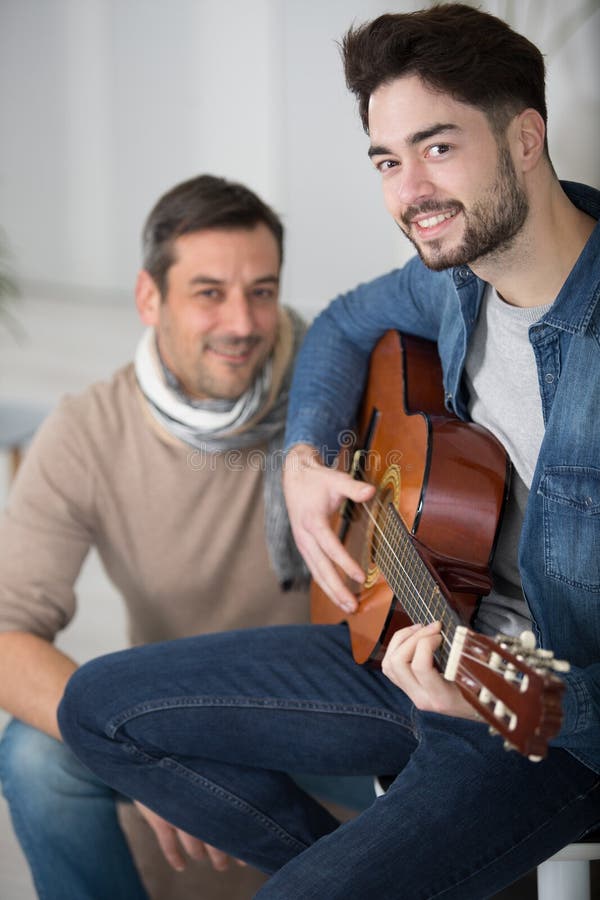 Two Casually Dressed Men One Playing Guitar Stock Photo - Image of ...