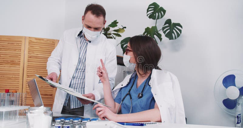 Two Caucasian Doctor Experts Consult with Each Other, Discuss Document ...