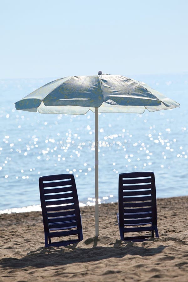 Two Plastic Chairs Stand on Beach Under Umbrella Stock Image - Image of ...