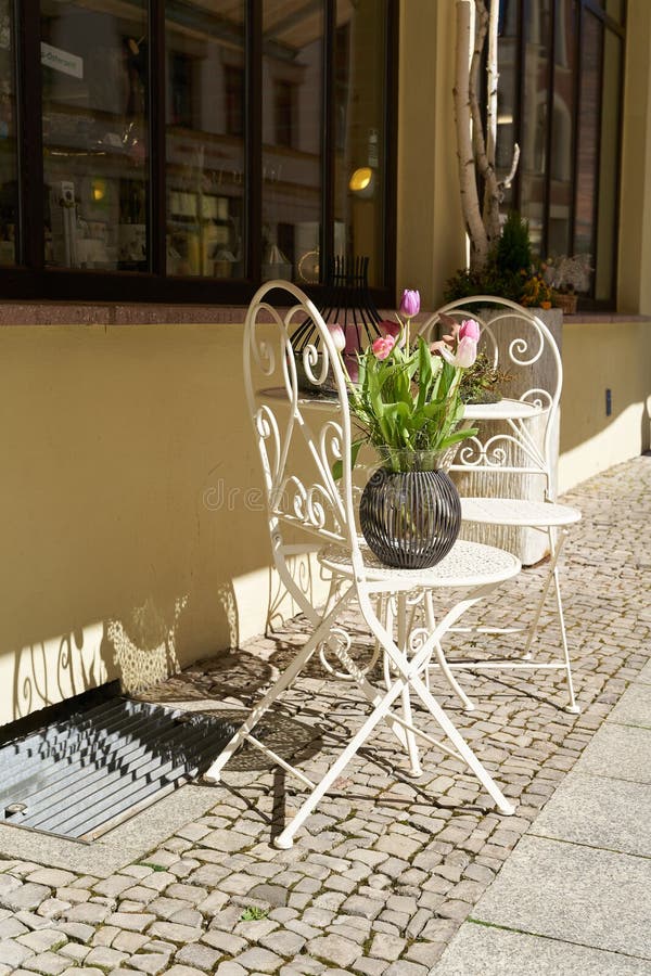 Two Chairs and a Table in Front of a Store for Decoration Articles in a ...