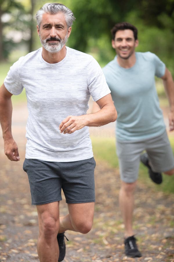 Two Cheerful Men Jogging in Park Stock Photo - Image of exercising ...