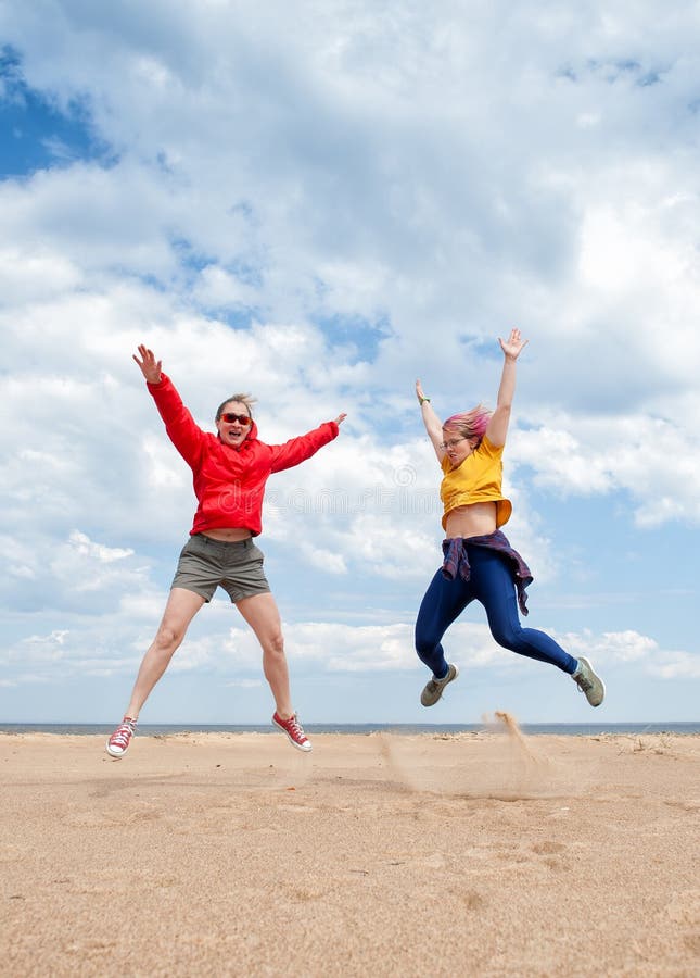 Two Cheerful Women Having Fun and Jumping on the Sand Stock Image ...