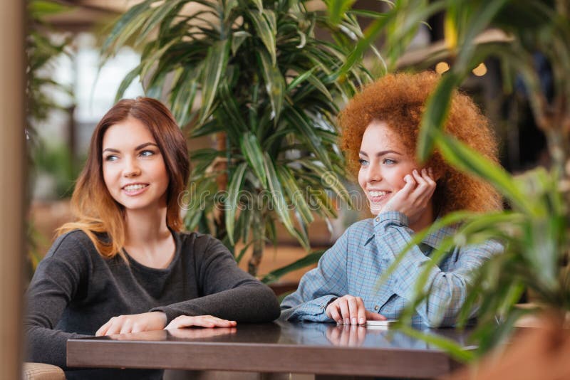 Two Cheerful Women Sitting in Cafe and Smiling Stock Photo - Image of ...