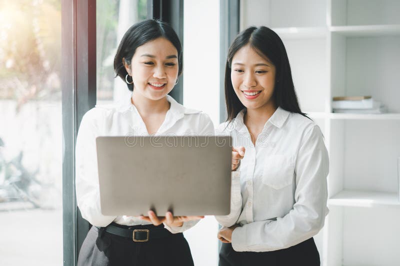 Two Cheerful Young Multinational Colleagues Talking while Standing in ...