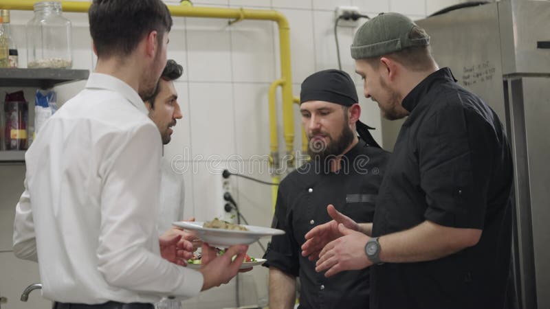 Two Chefs in Black Uniforms Together with Waiters in White Shirts ...
