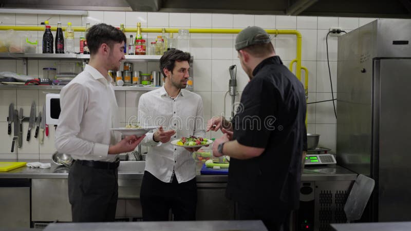 Two Chefs in Black Uniforms and Waiters Communicate about Serving and ...