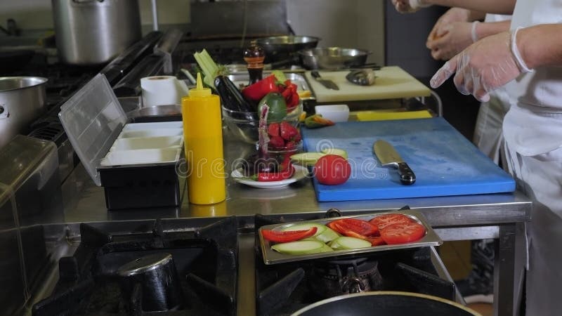 Two Chefs in White Uniforms Work in a Large Professional Kitchen. Stock ...