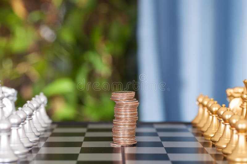 Two Chess Pieces on a Chess Board and a Stack of Dollar Coins in the ...