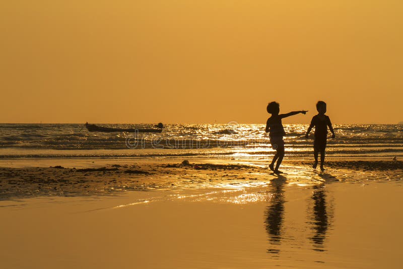 Two Child Shadows on the Beach with Gold Light Sunset Stock Photo ...